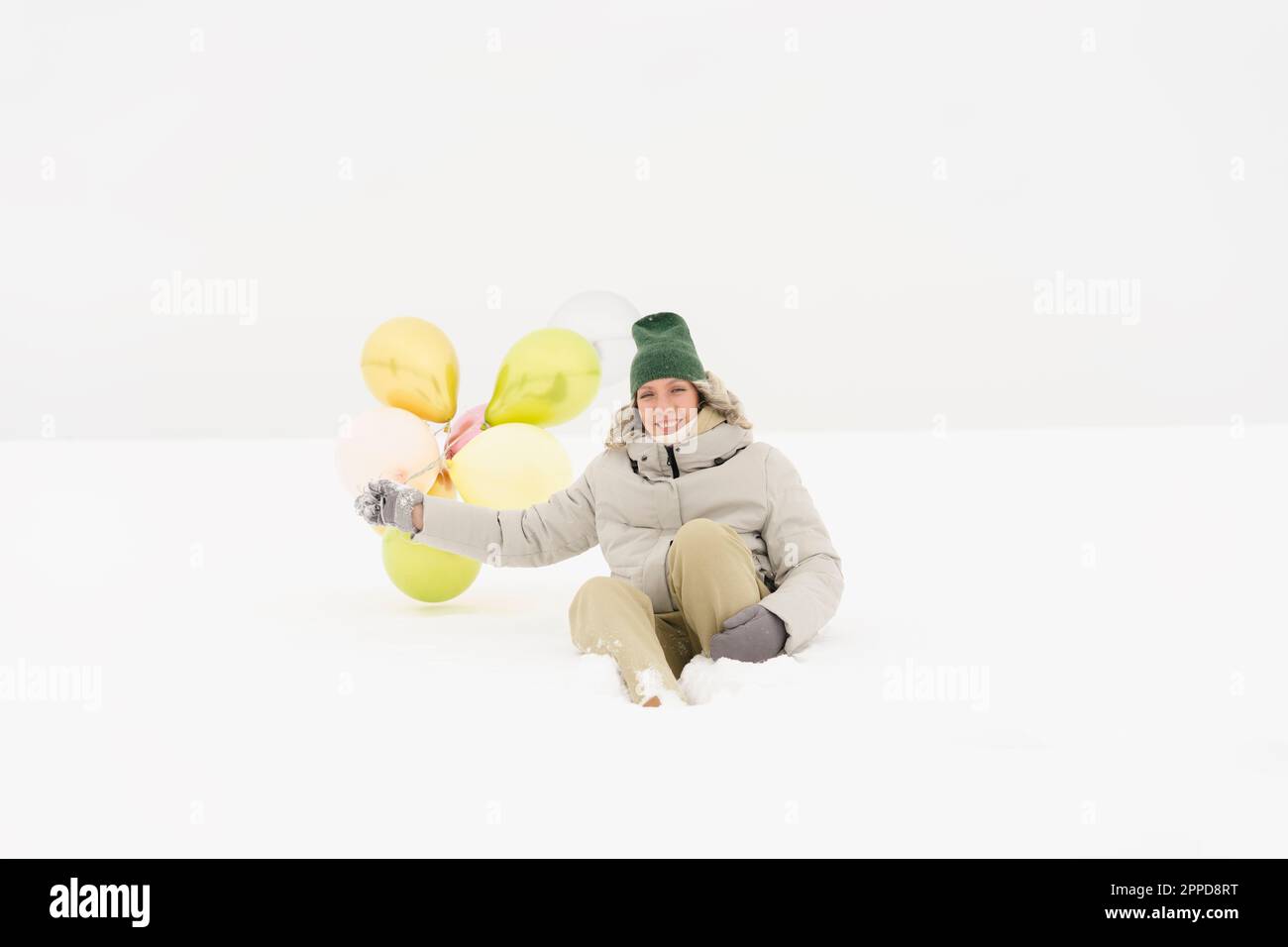 Happy woman with balloons having fun in snow Stock Photo - Alamy