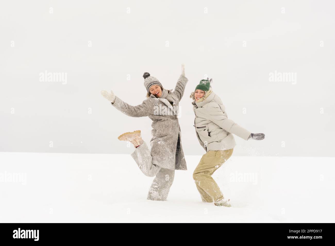 Carefree friends dancing together on snow in winter Stock Photo - Alamy