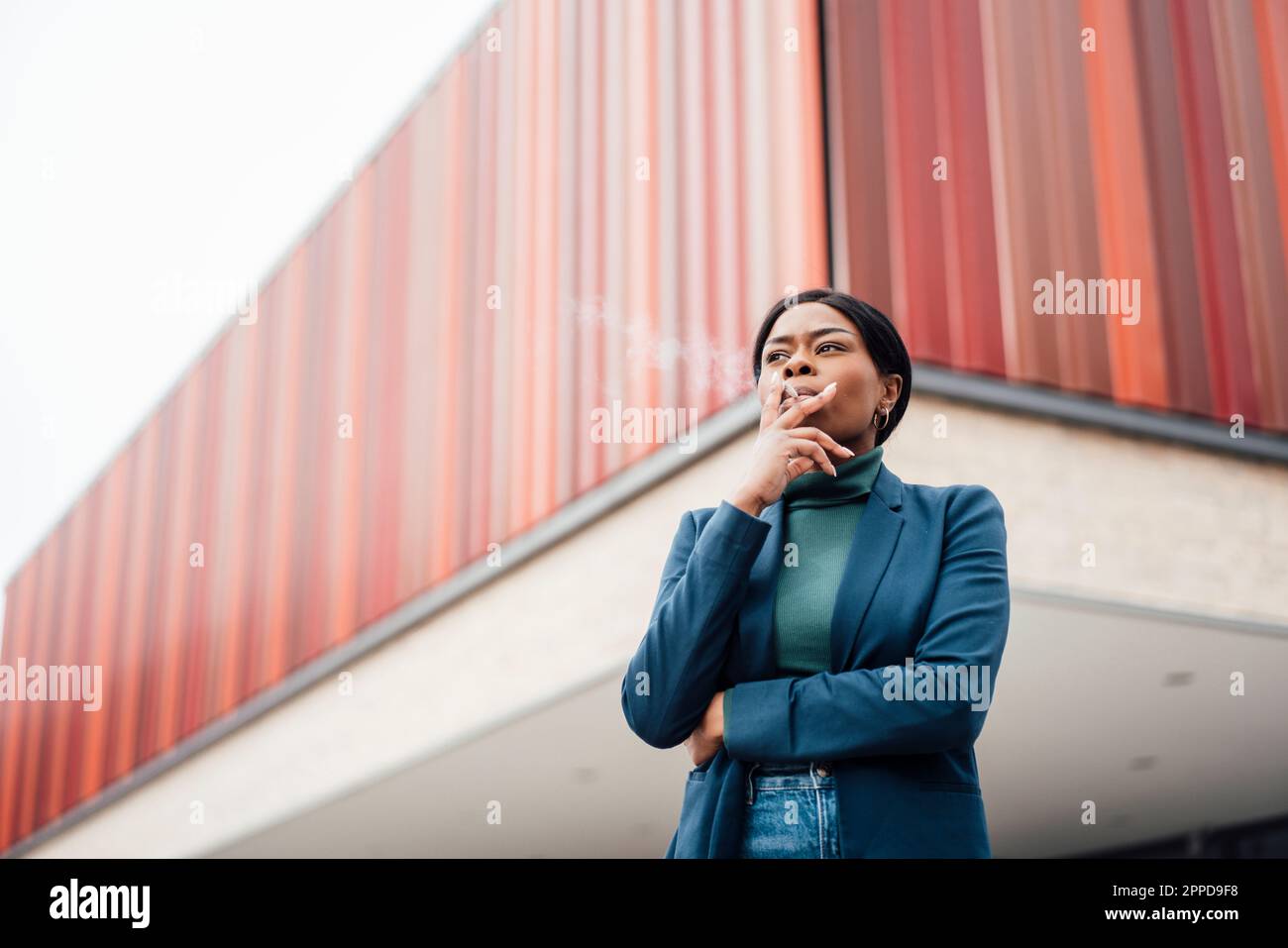 Stressed businesswoman smoking cigarette in front of building Stock ...