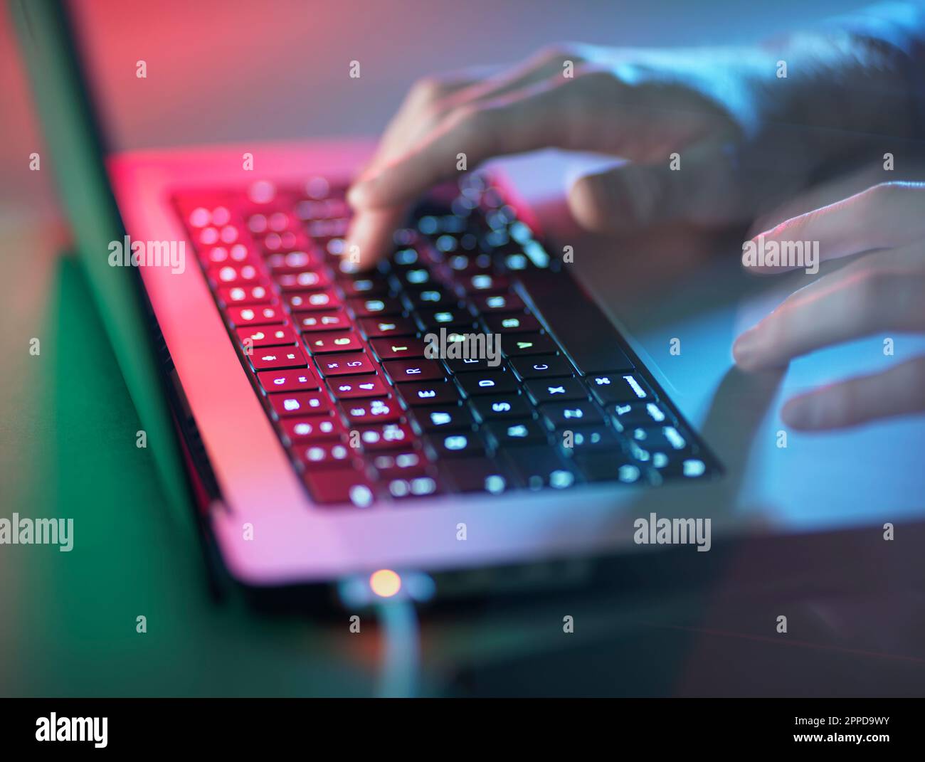 Hacker working on illuminated laptop at office Stock Photo - Alamy
