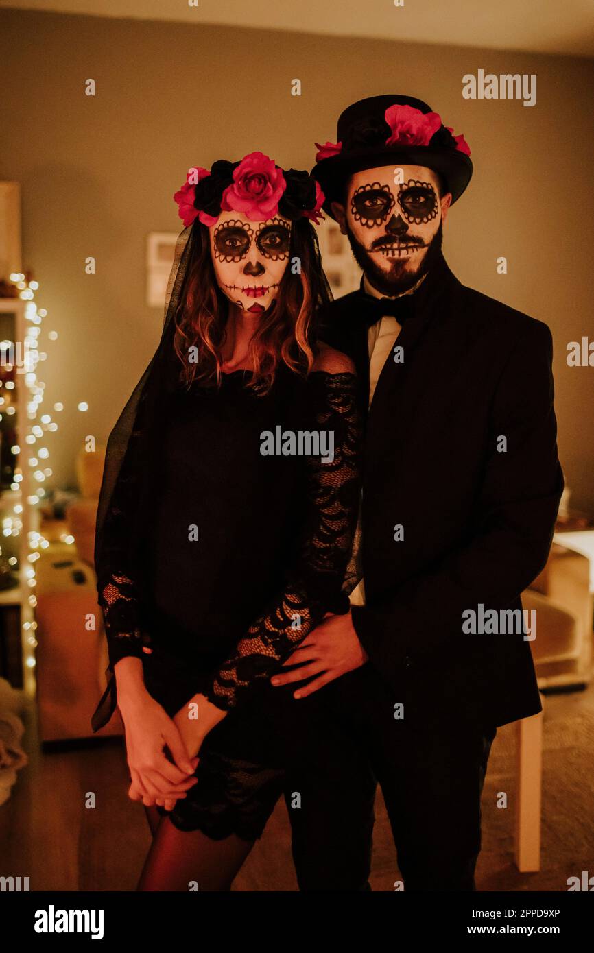 Couple wearing Day of the Dead costumes standing at home Stock Photo ...