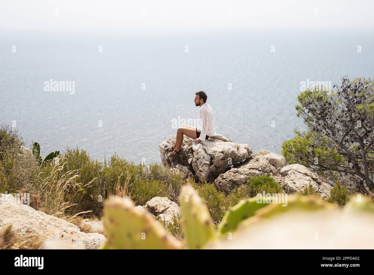Man sitting alone on sea hi-res stock photography and images - Alamy