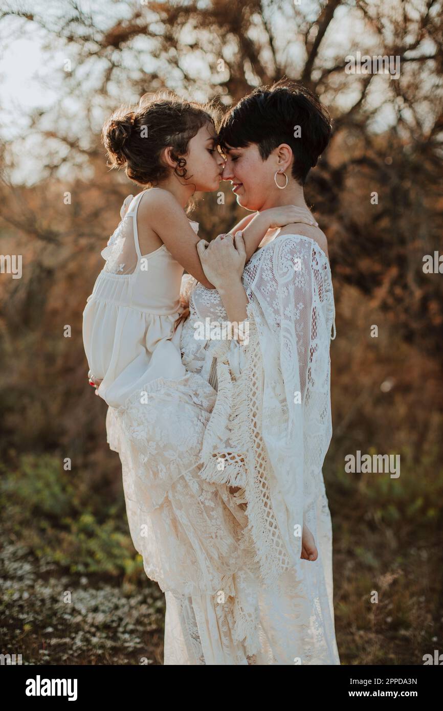 Girl kissing mother on nose at sunset Stock Photo - Alamy