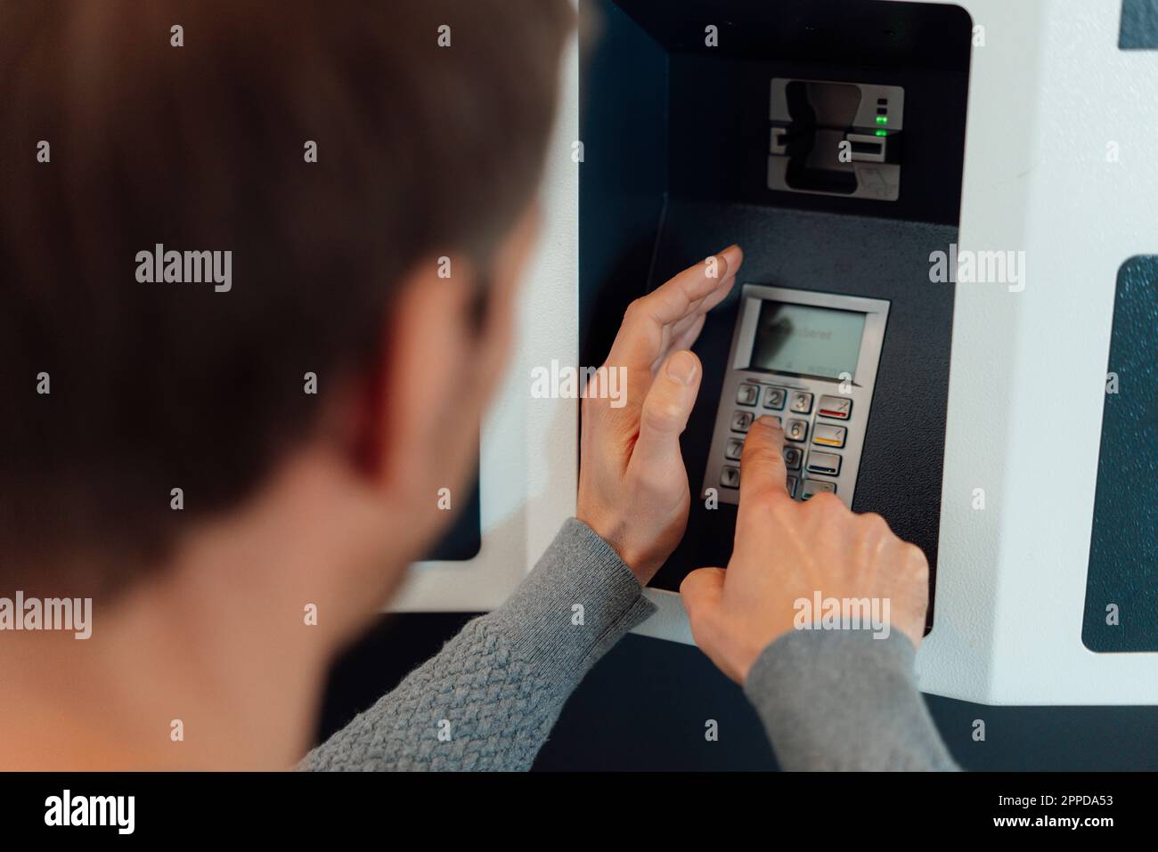 Man entering pin in ATM machine Stock Photo - Alamy