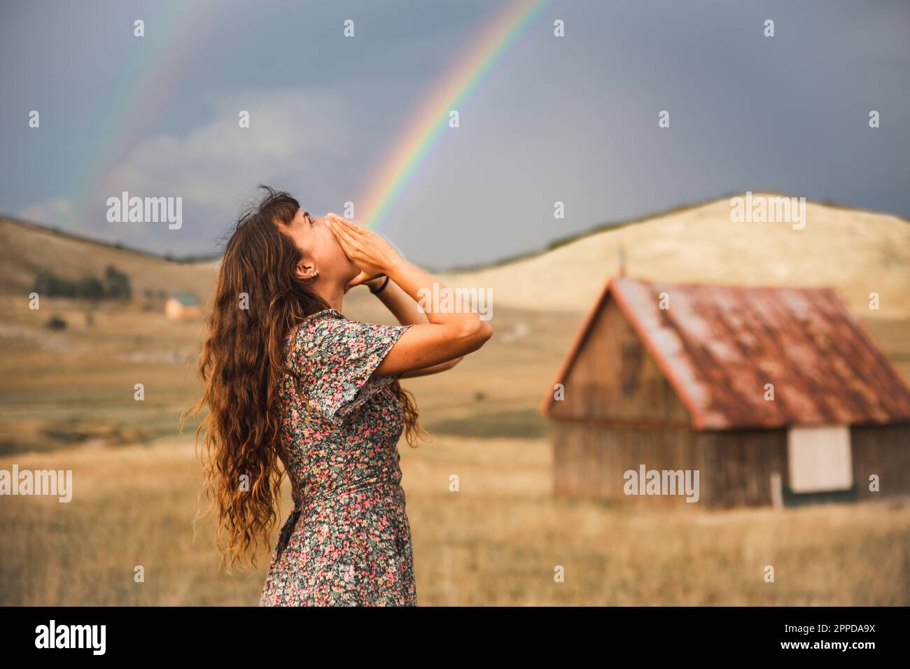 Optical illusion of rainbow coming out from mouth of woman standing in ...