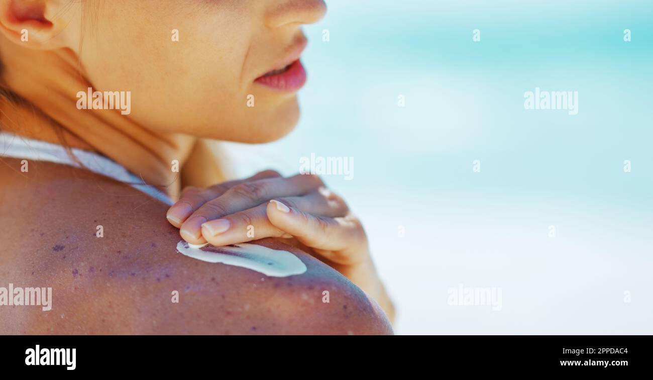 Closeup on young woman applying sun screen creme Stock Photo - Alamy