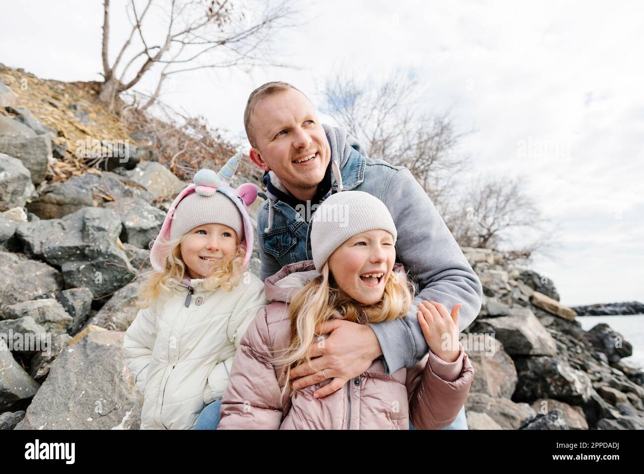 Happy father enjoying with daughters by rocks Stock Photo - Alamy