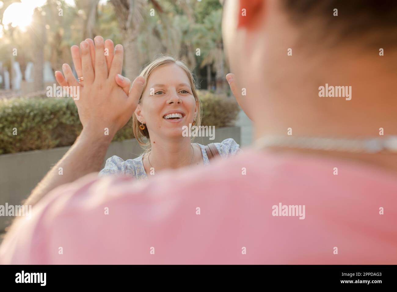 Smiling woman giving high-five to man Stock Photo - Alamy