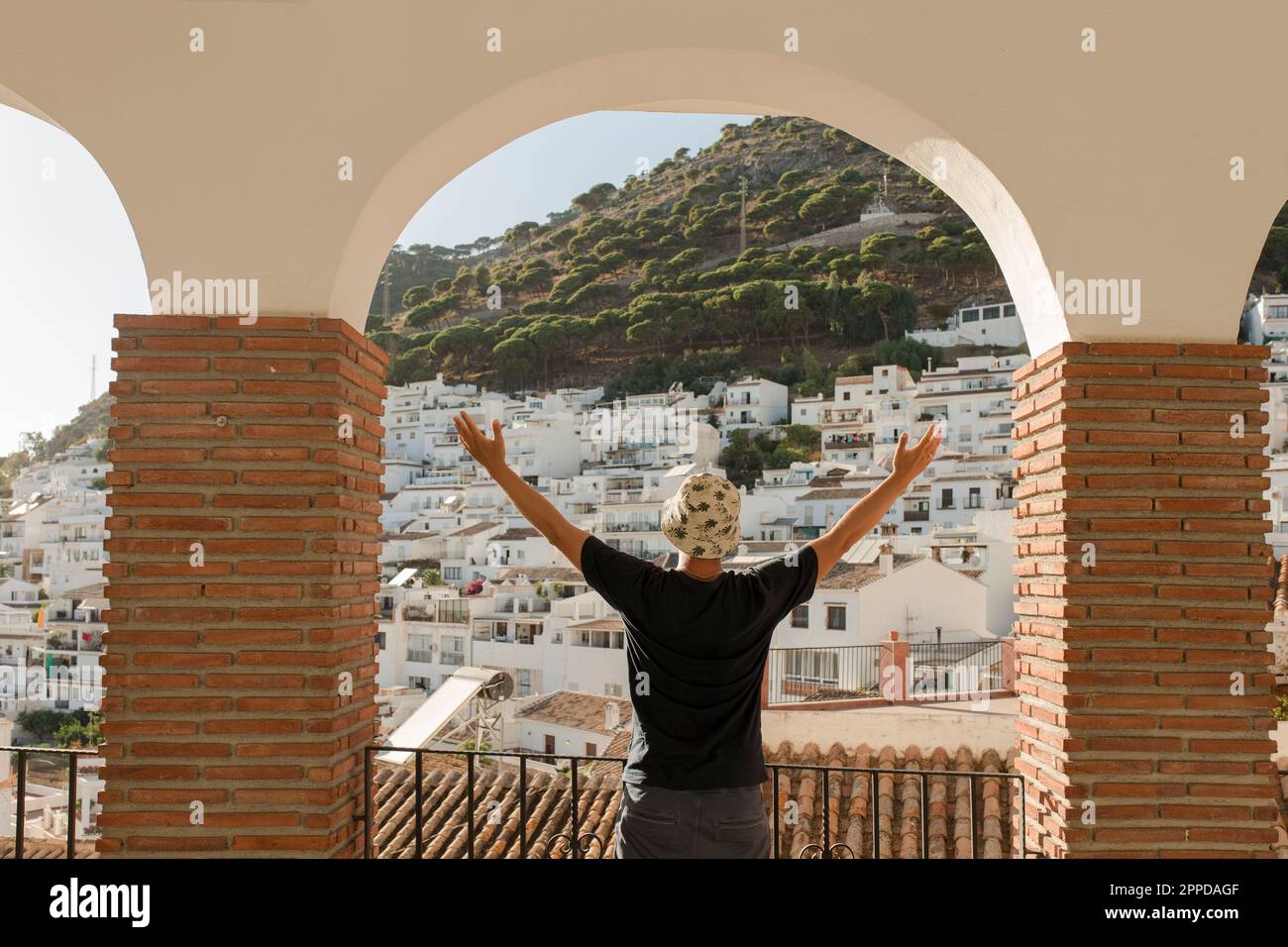 Man with arms raised standing under arch Stock Photo - Alamy