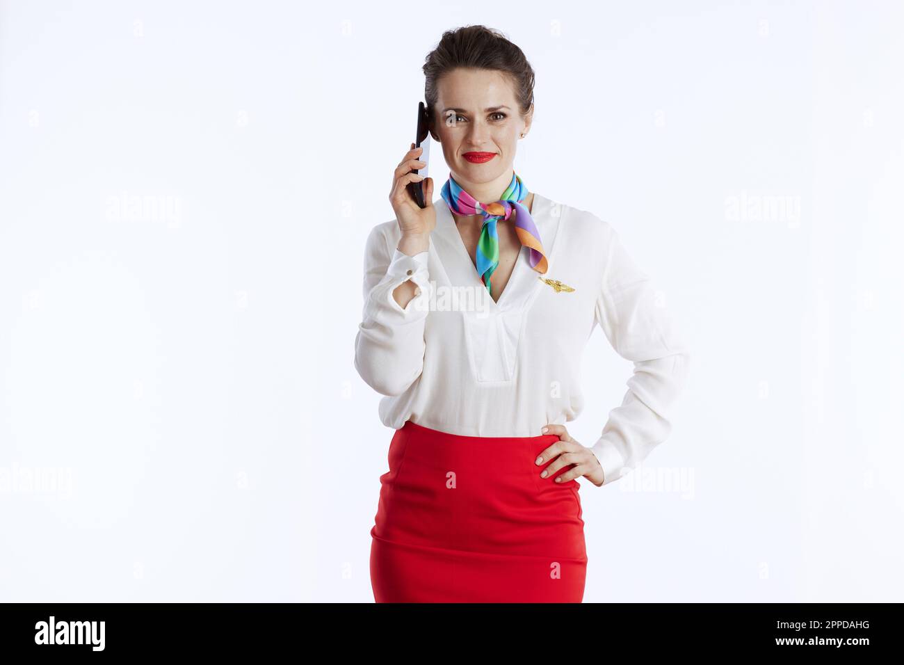 smiling stylish female air hostess against white background in uniform ...