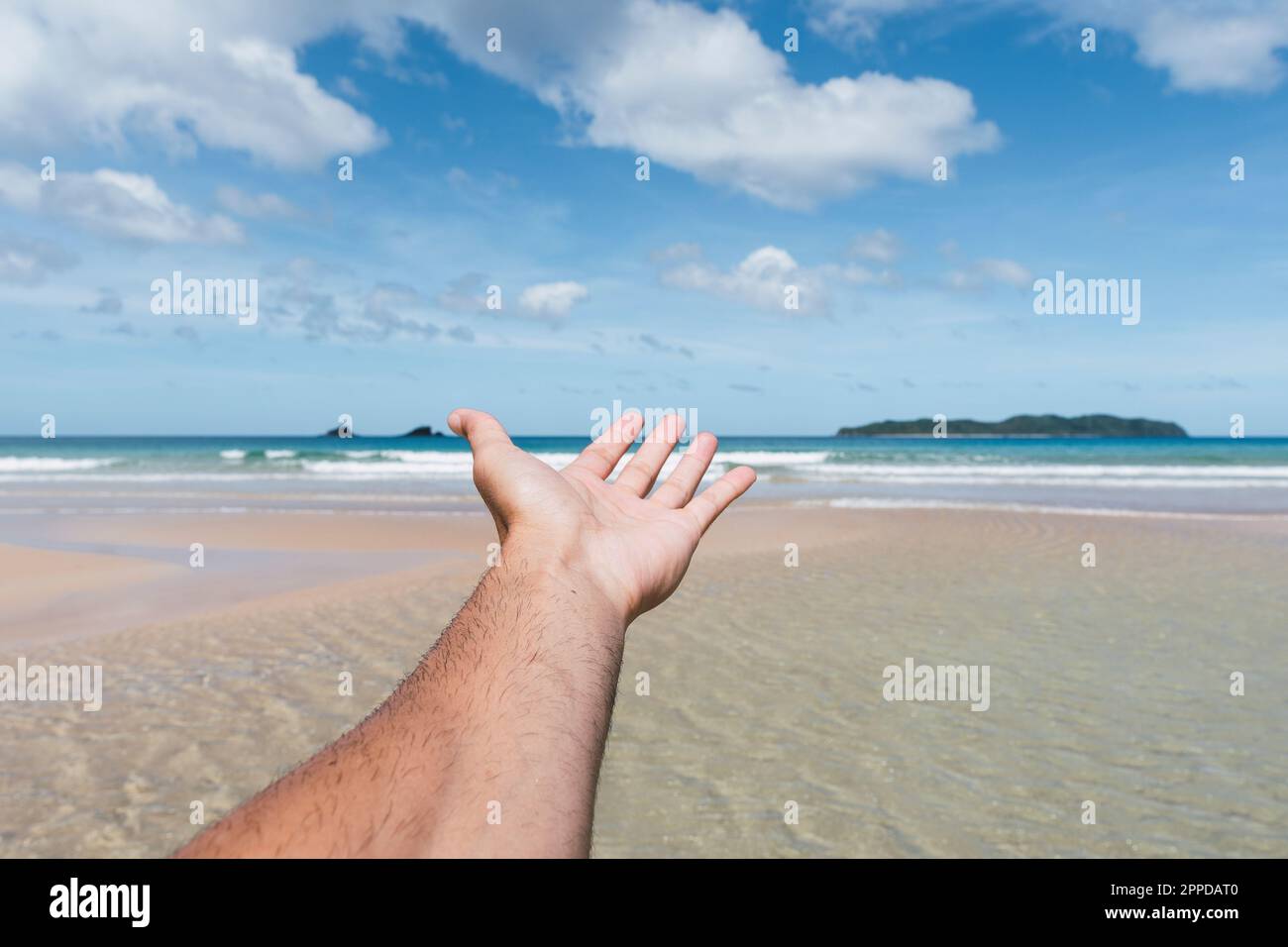 Man's hand reaching towards sea at beach Stock Photo - Alamy