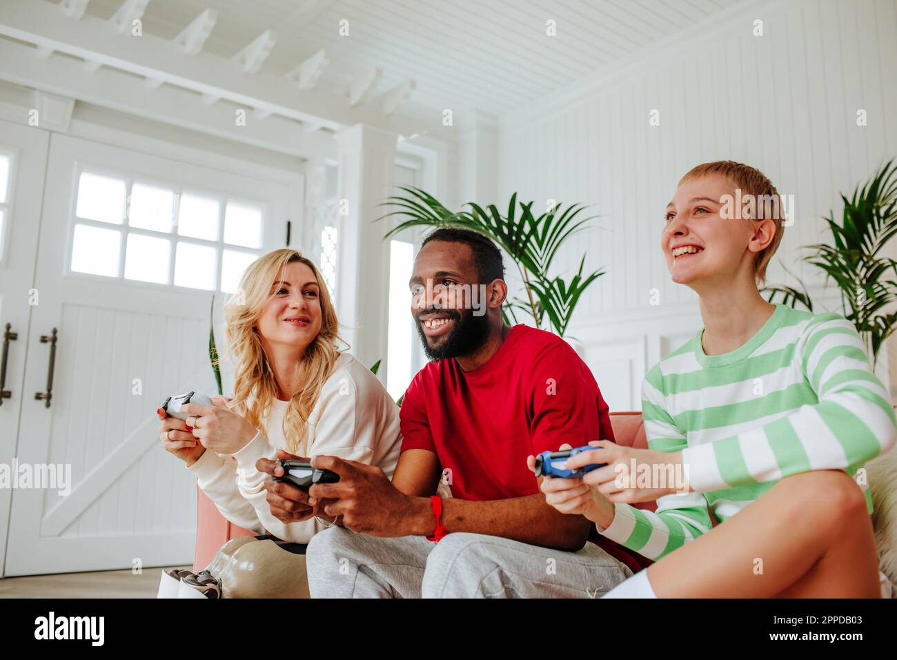 Happy multiracial friends playing video game together at home Stock ...