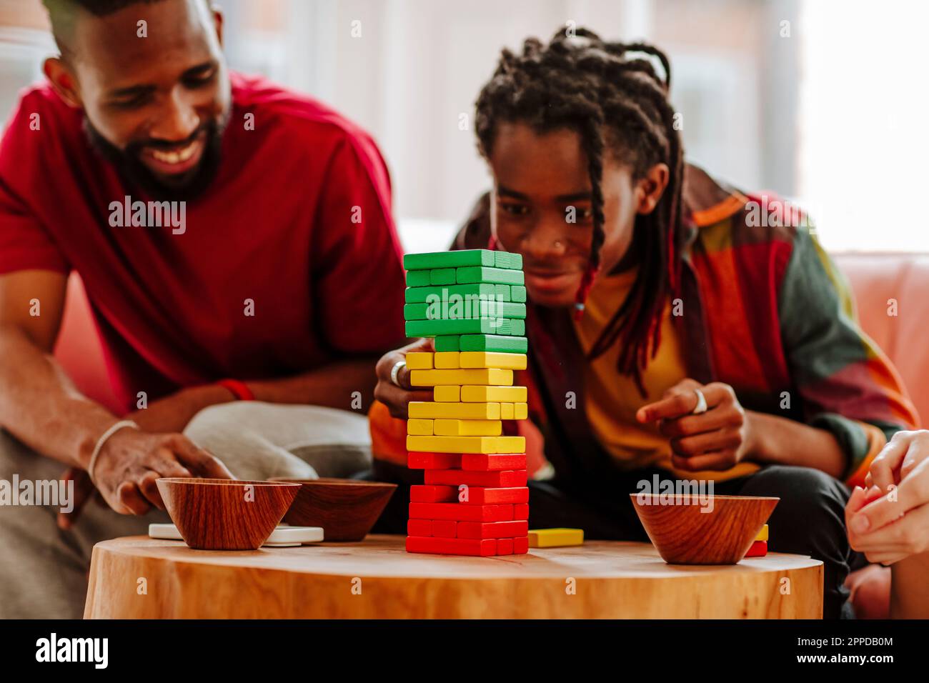 Happy friends playing with toy blocks at home Stock Photo - Alamy