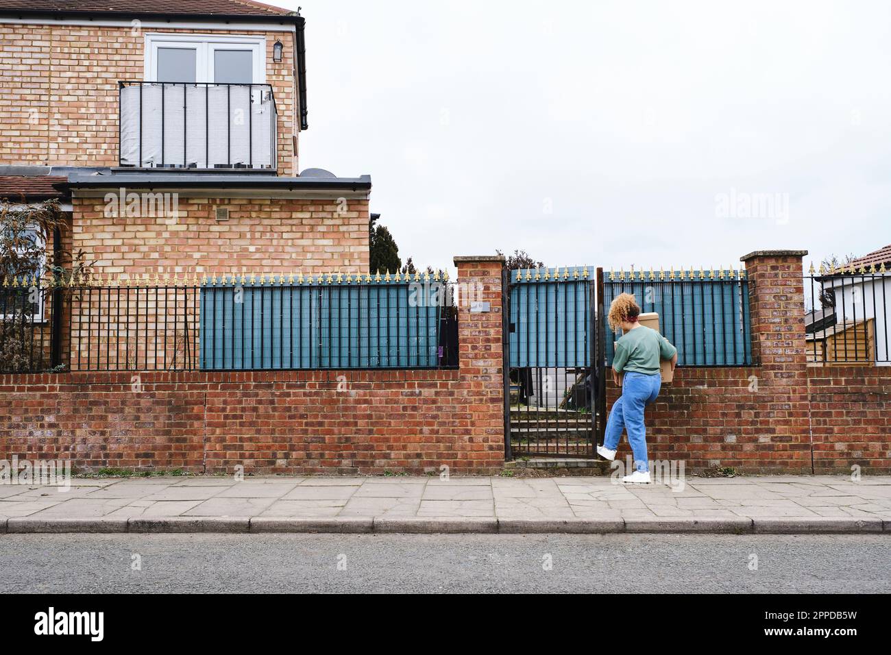 Young woman opening door and delivering packages Stock Photo - Alamy