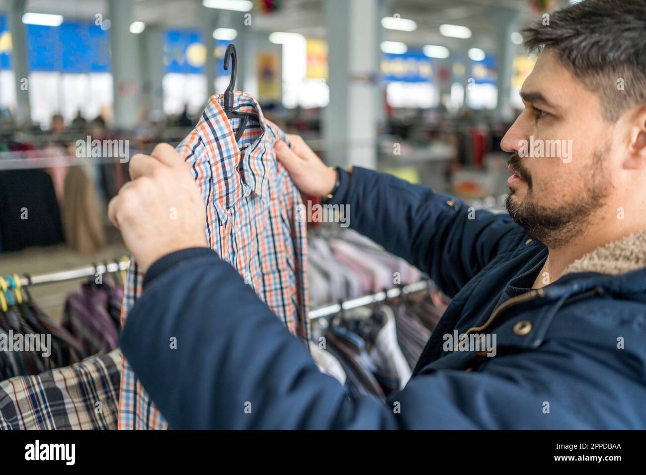 Man looking at clothes in store Stock Photo - Alamy