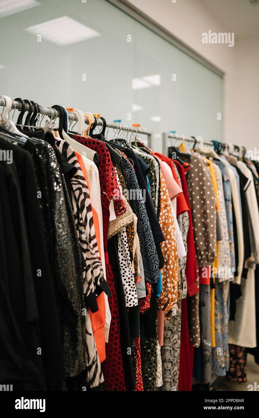 Various dresses hanging on clothing rack in store Stock Photo - Alamy
