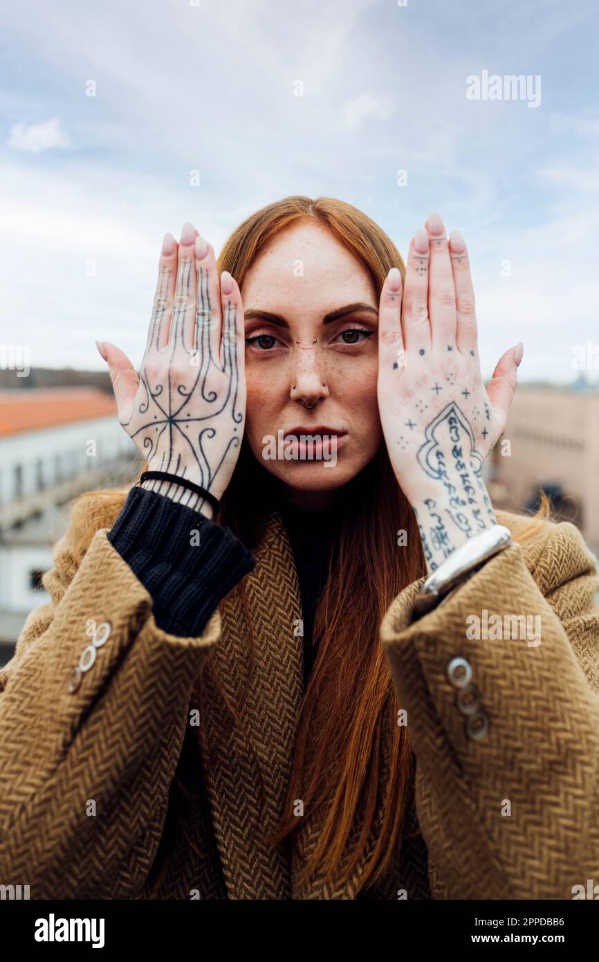 Woman showing tattooed hand on terrace Stock Photo - Alamy