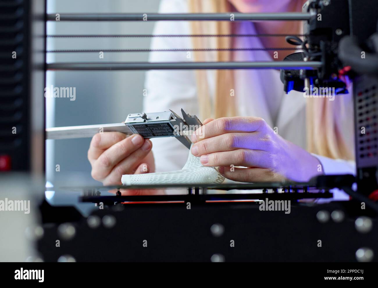 Hands of woman using vernier calliper at 3D printing machine in ...