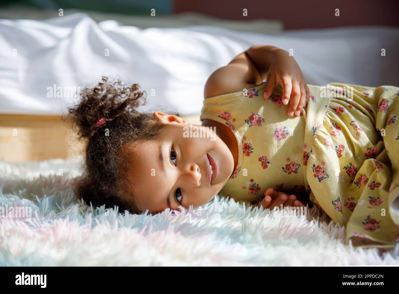 Cute girl lying on rug at home Stock Photo - Alamy