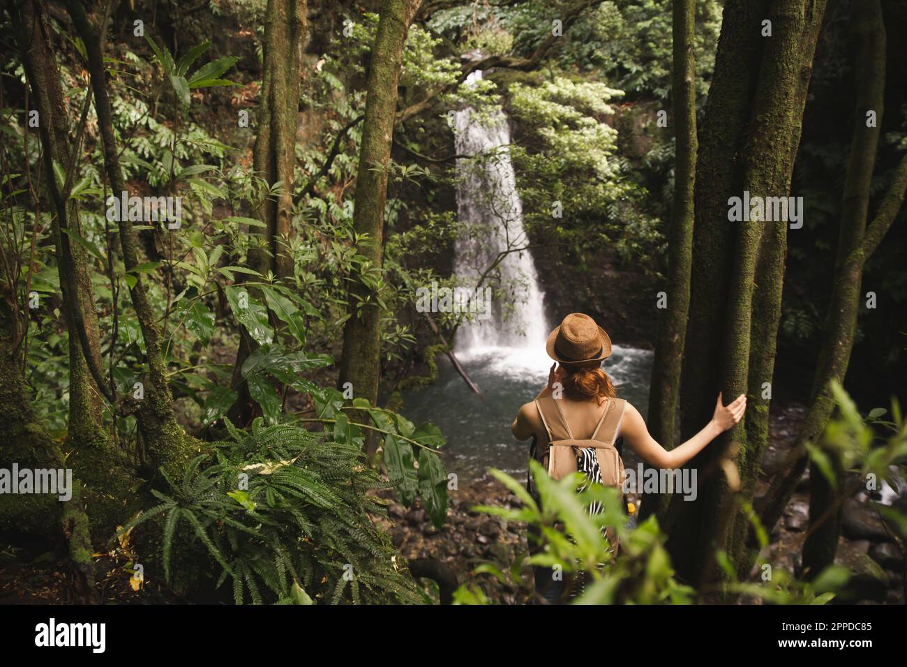 Woman wearing hat standing in front of waterfall Stock Photo - Alamy