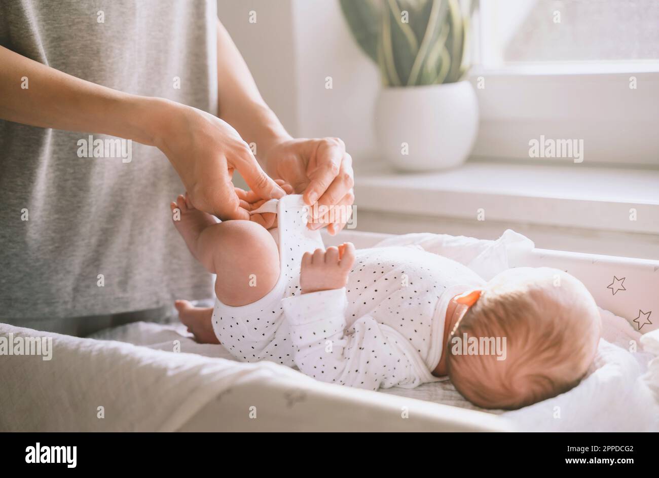 Mother changing clothes of baby at home Stock Photo - Alamy