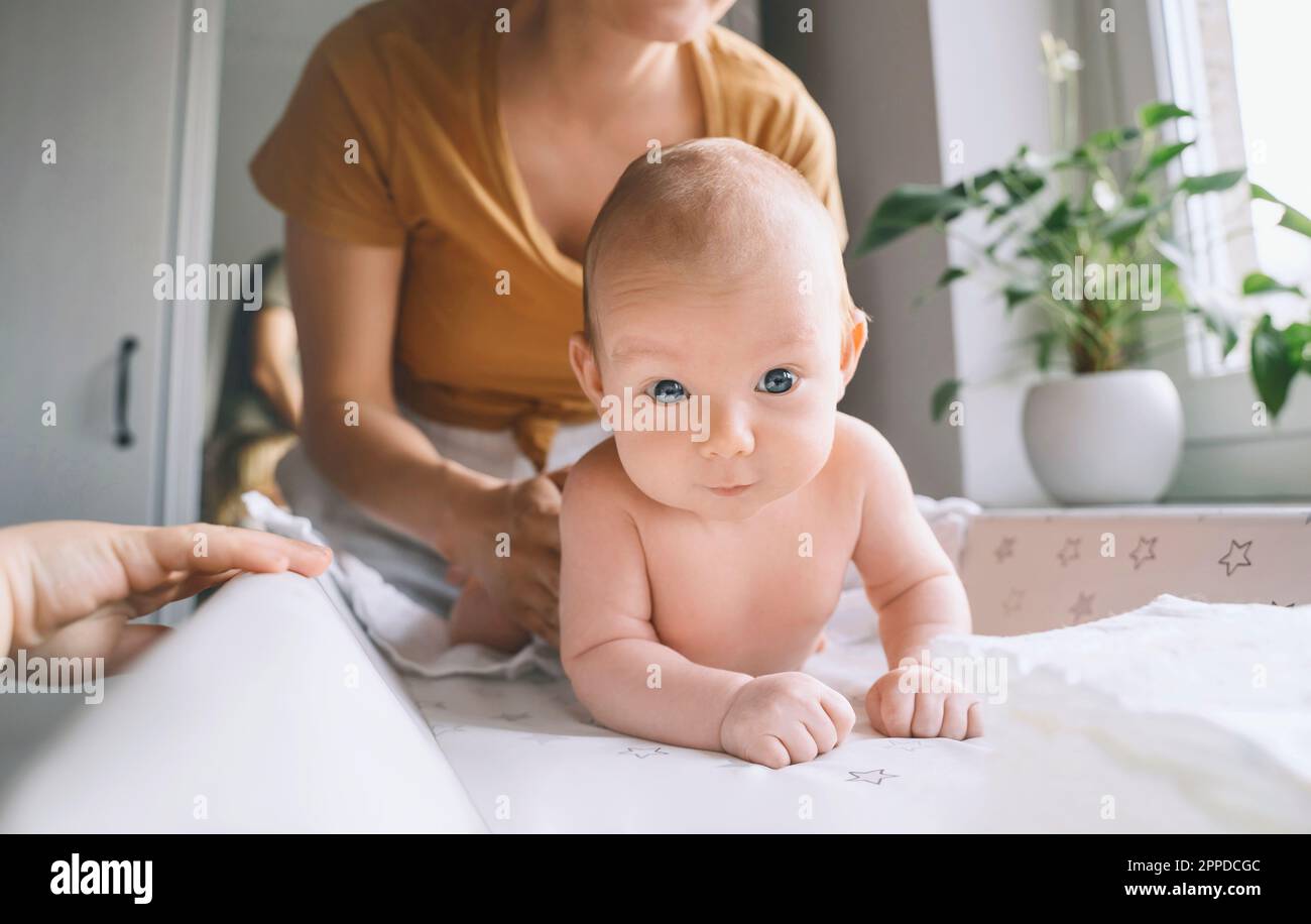 Sister helping mother taking care of baby at home Stock Photo - Alamy