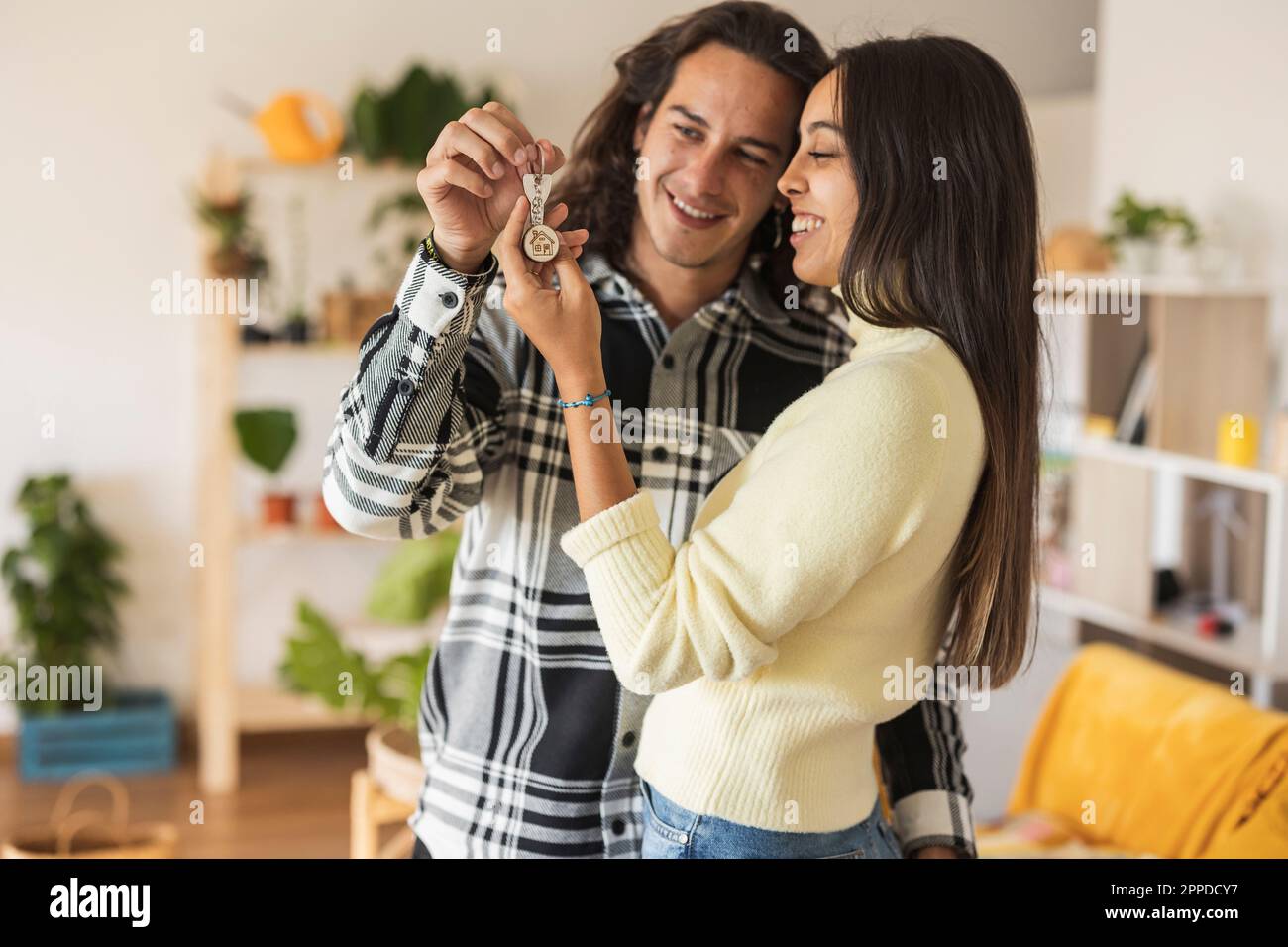 Happy girlfriend and boyfriend looking at new house key Stock Photo - Alamy