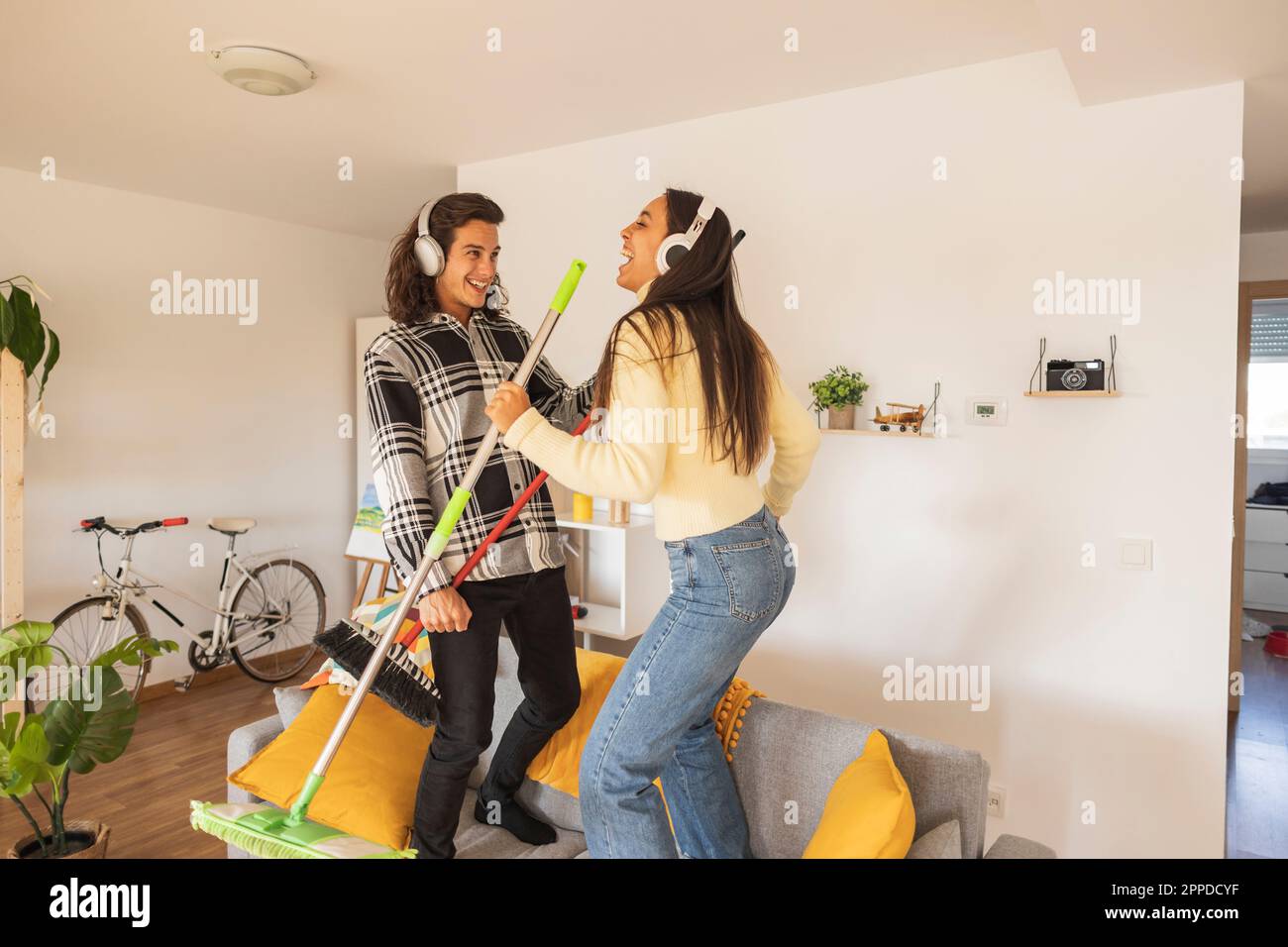 Happy couple having fun doing housework Stock Photo - Alamy