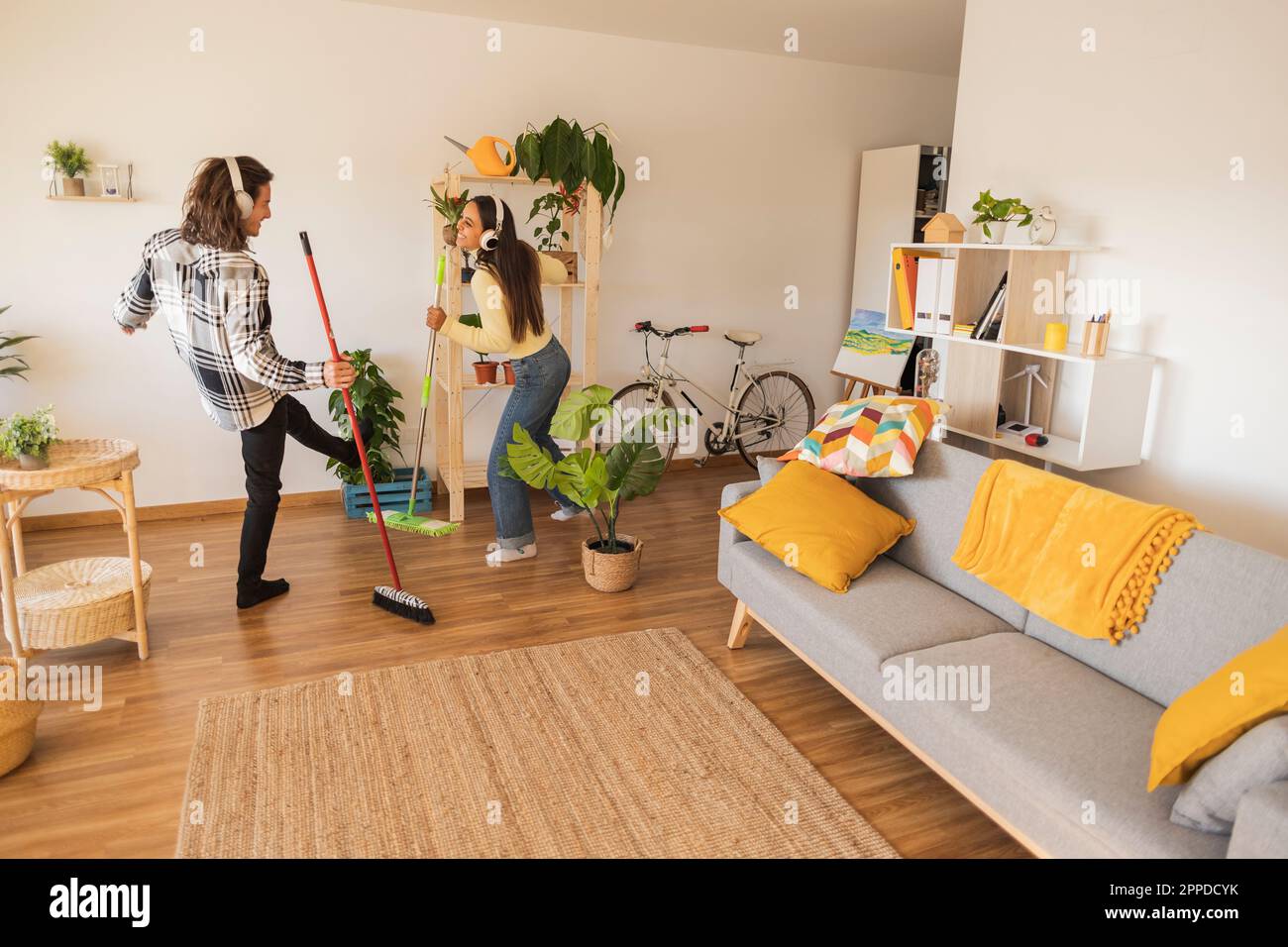 Happy couple having fun dancing and cleaning new home Stock Photo - Alamy