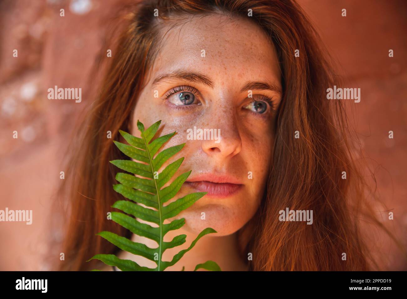 Woman holding leaf over head hi-res stock photography and images - Alamy