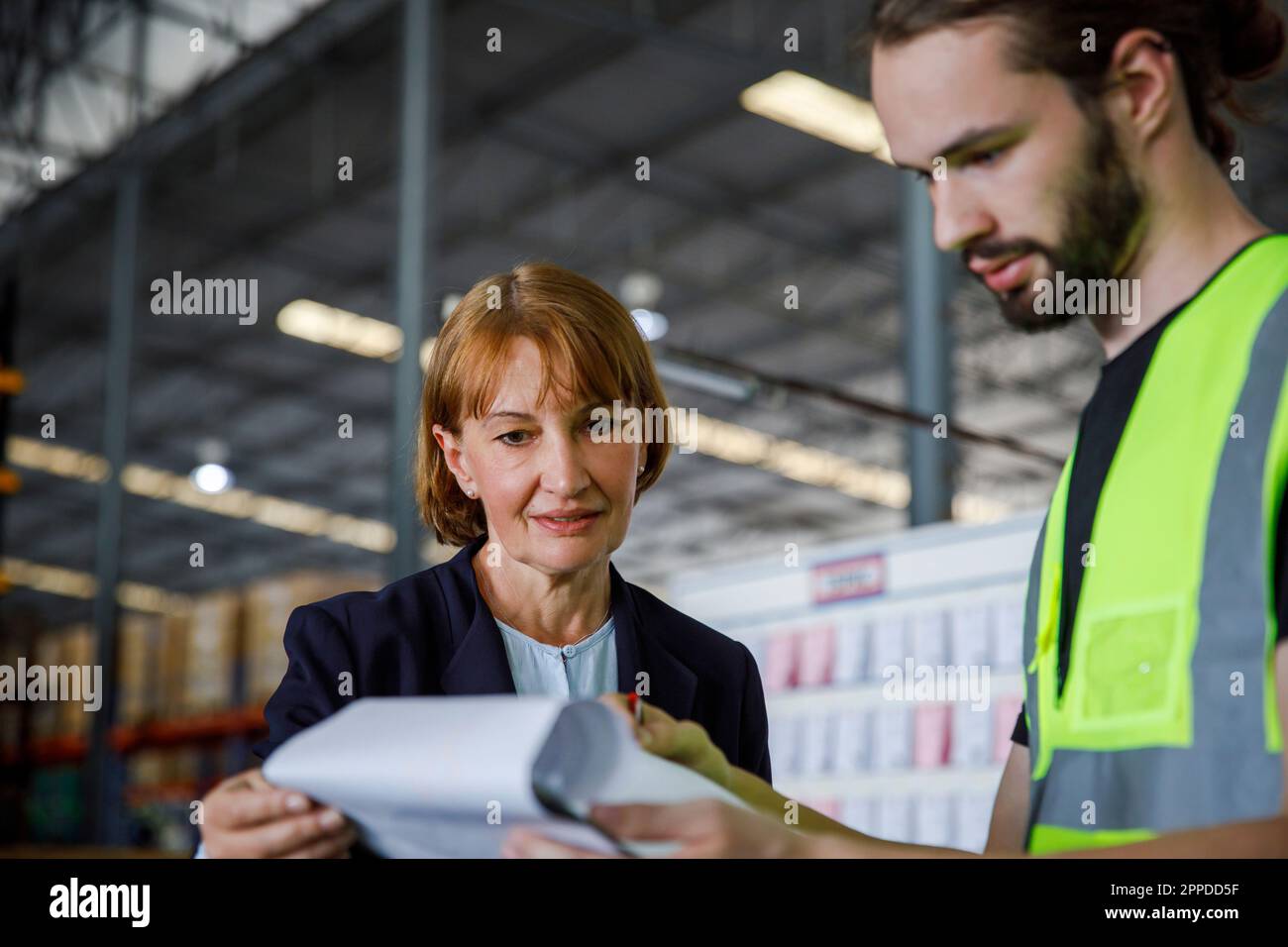 Manager and colleague examining checklist at warehouse Stock Photo - Alamy