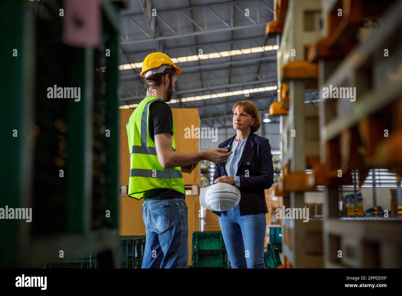 Manager and colleague discussing at warehouse Stock Photo - Alamy