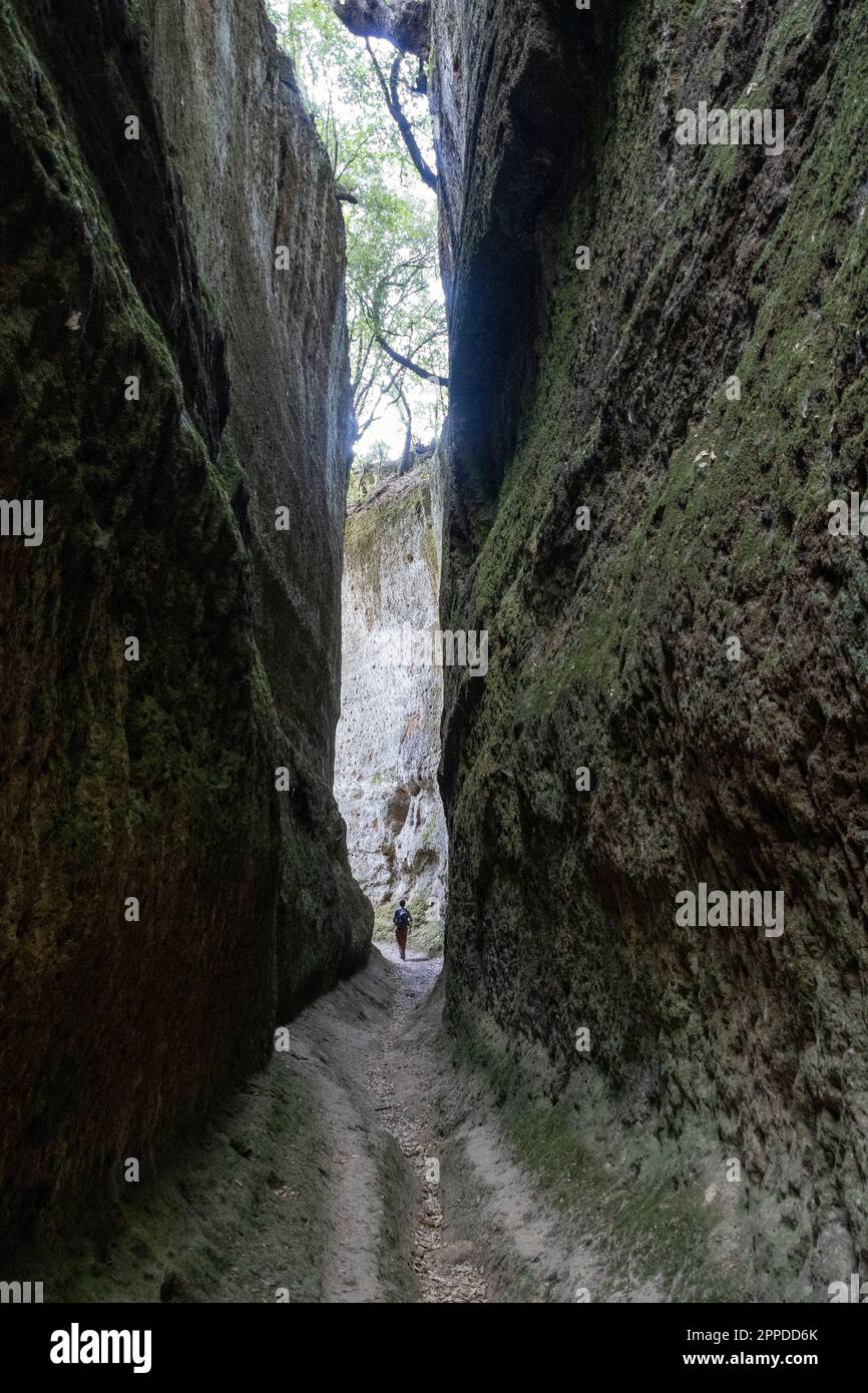 Man walking on narrow pathway amidst rocks, Tuscany, Italy Stock Photo ...