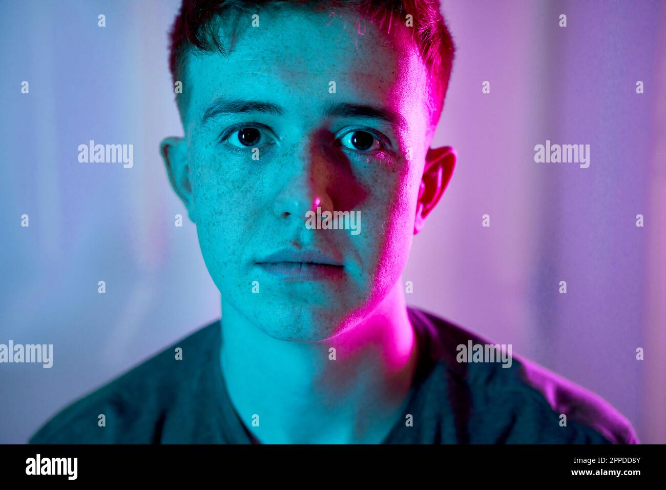 Sad young man with illuminated neon lighting on face Stock Photo - Alamy