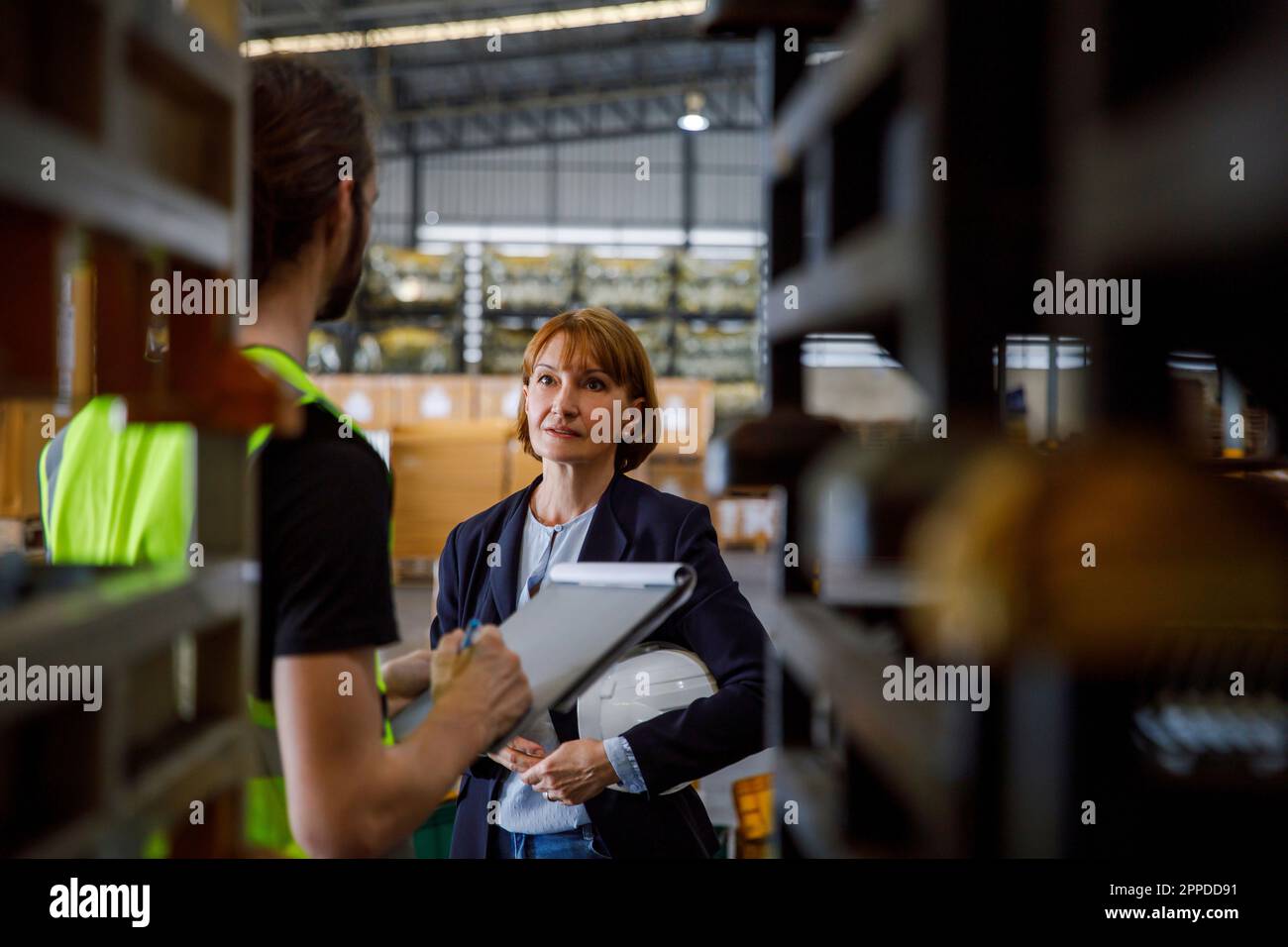 Manager with colleague checking with checklist at warehouse Stock Photo ...