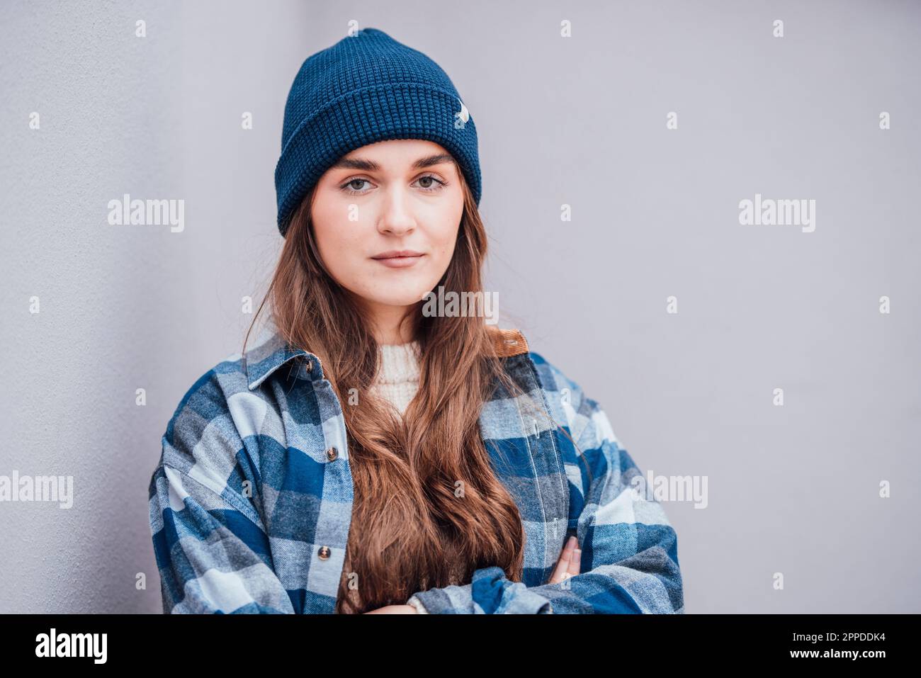 Young woman wearing knit hat in front of wall Stock Photo - Alamy