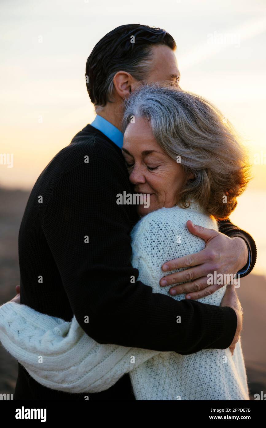 Happy mature couple hugging each other at beach Stock Photo - Alamy