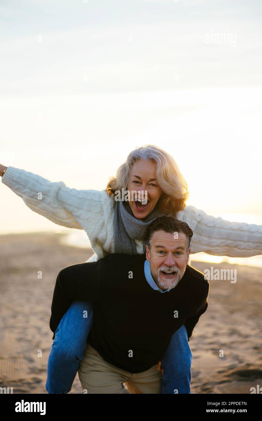 Mature man giving piggyback ride to woman hi-res stock photography and ...