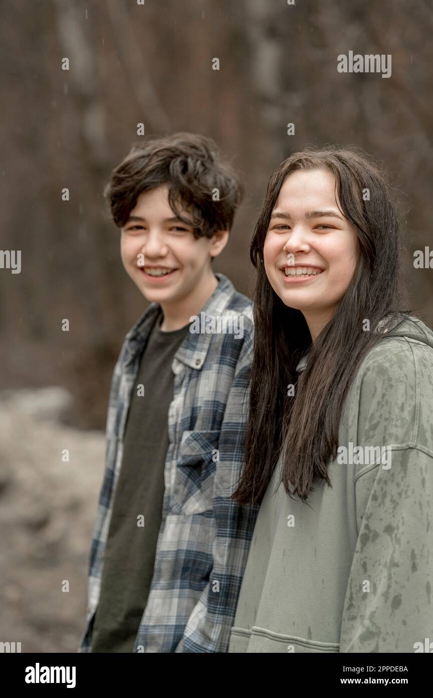 Smiling teenage siblings in casuals on rainy day Stock Photo - Alamy