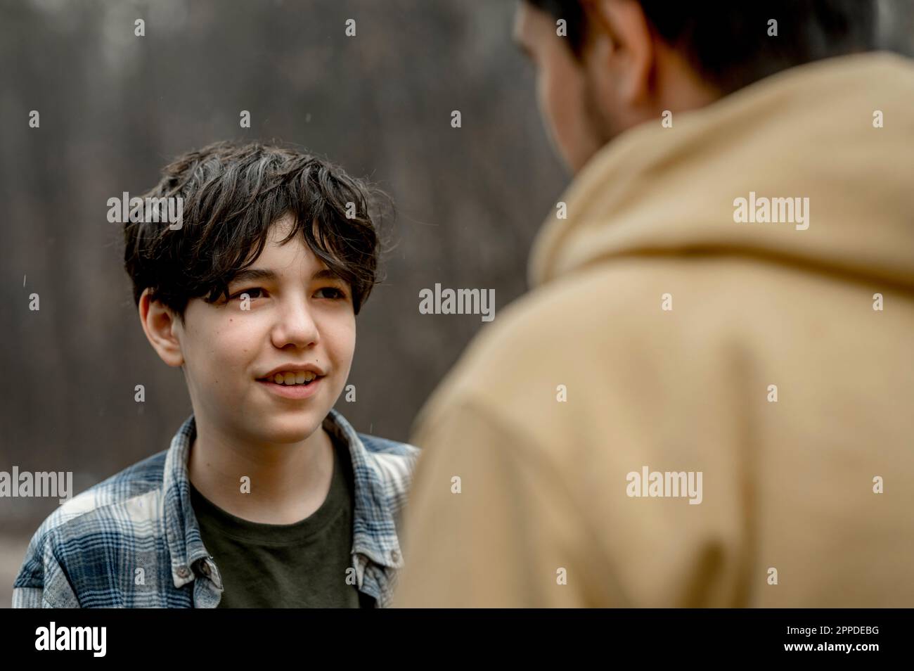 Smiling teenage boy talking with father Stock Photo - Alamy