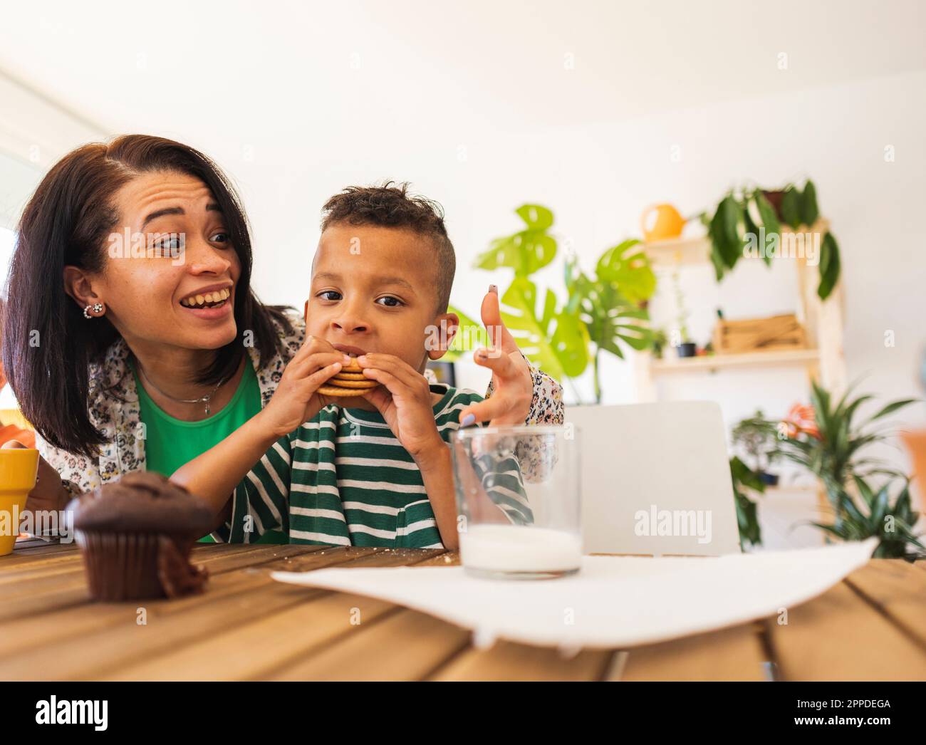 Boy eating biscuits by mother at home Stock Photo - Alamy