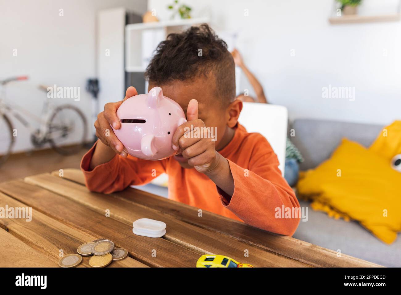 Boy opening piggy bank to count coins at home Stock Photo - Alamy