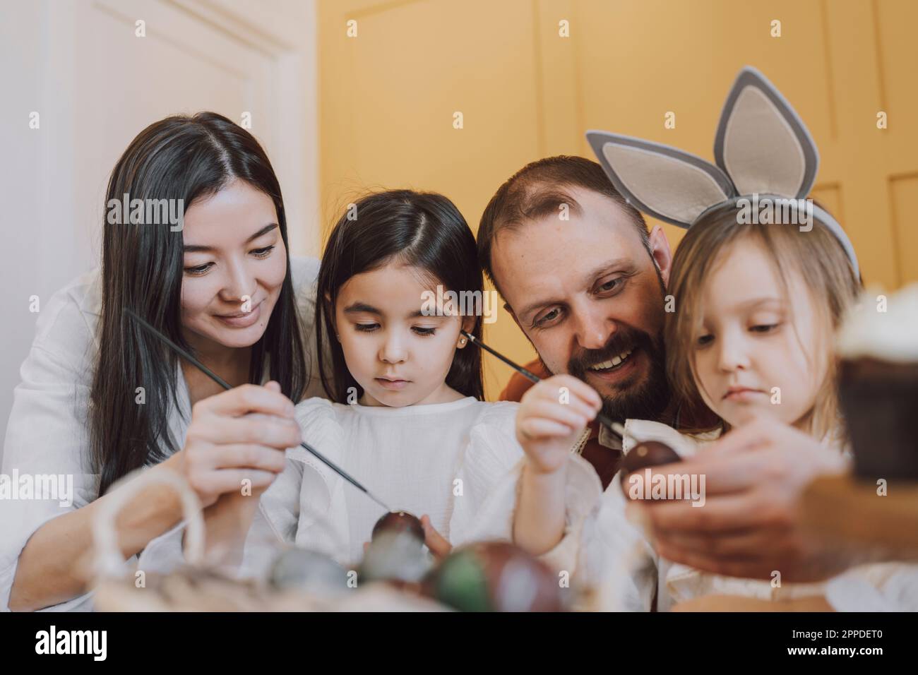 Parents and daughters decorating Easter eggs at home Stock Photo - Alamy