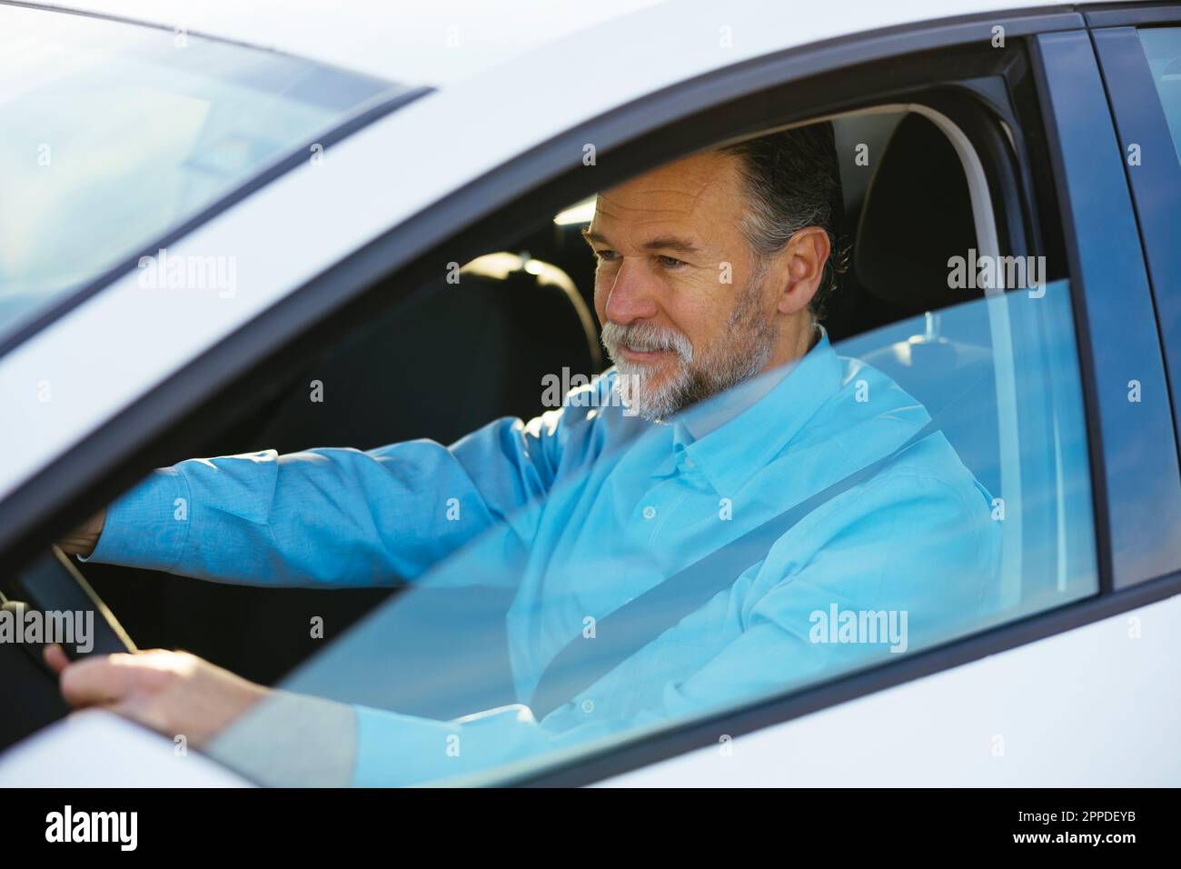 Mature man driving car seen through window Stock Photo - Alamy