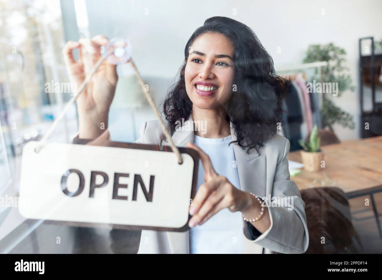 Women hanging open sign hi-res stock photography and images - Alamy