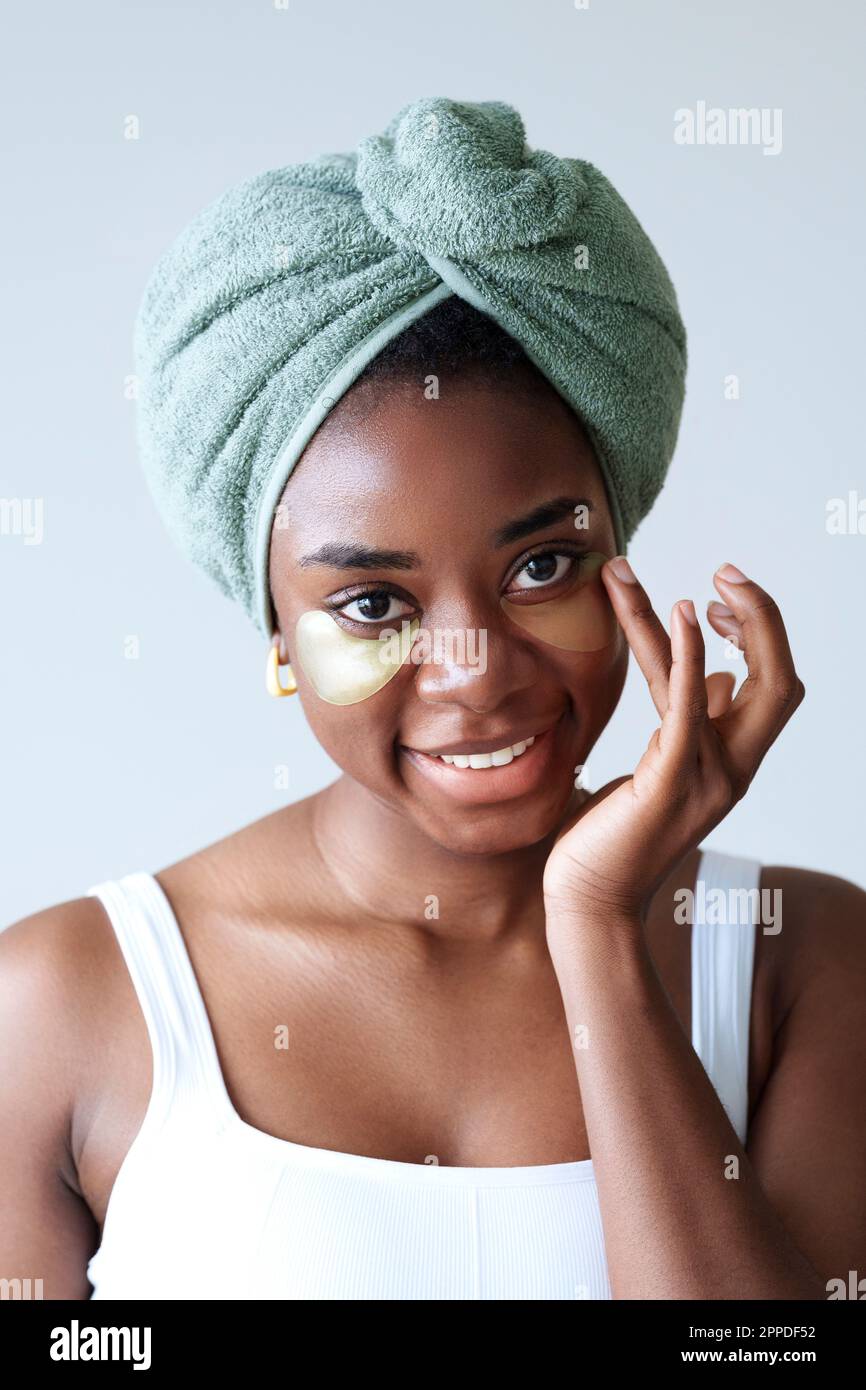 Happy young woman wearing towel on head in front of wall Stock Photo ...