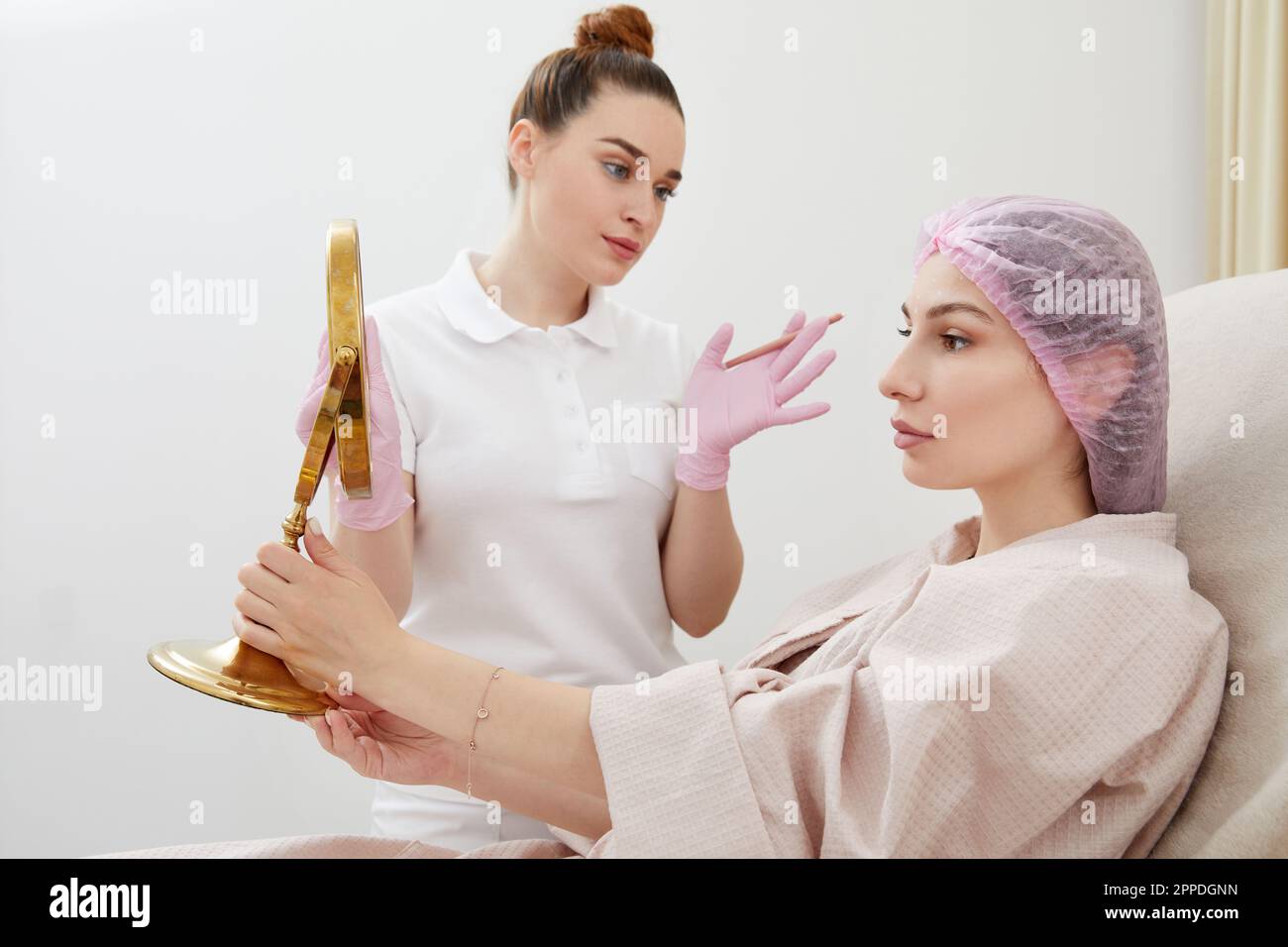 Cosmetologist drawing with white pencil on patient face. Cosmetologist ...