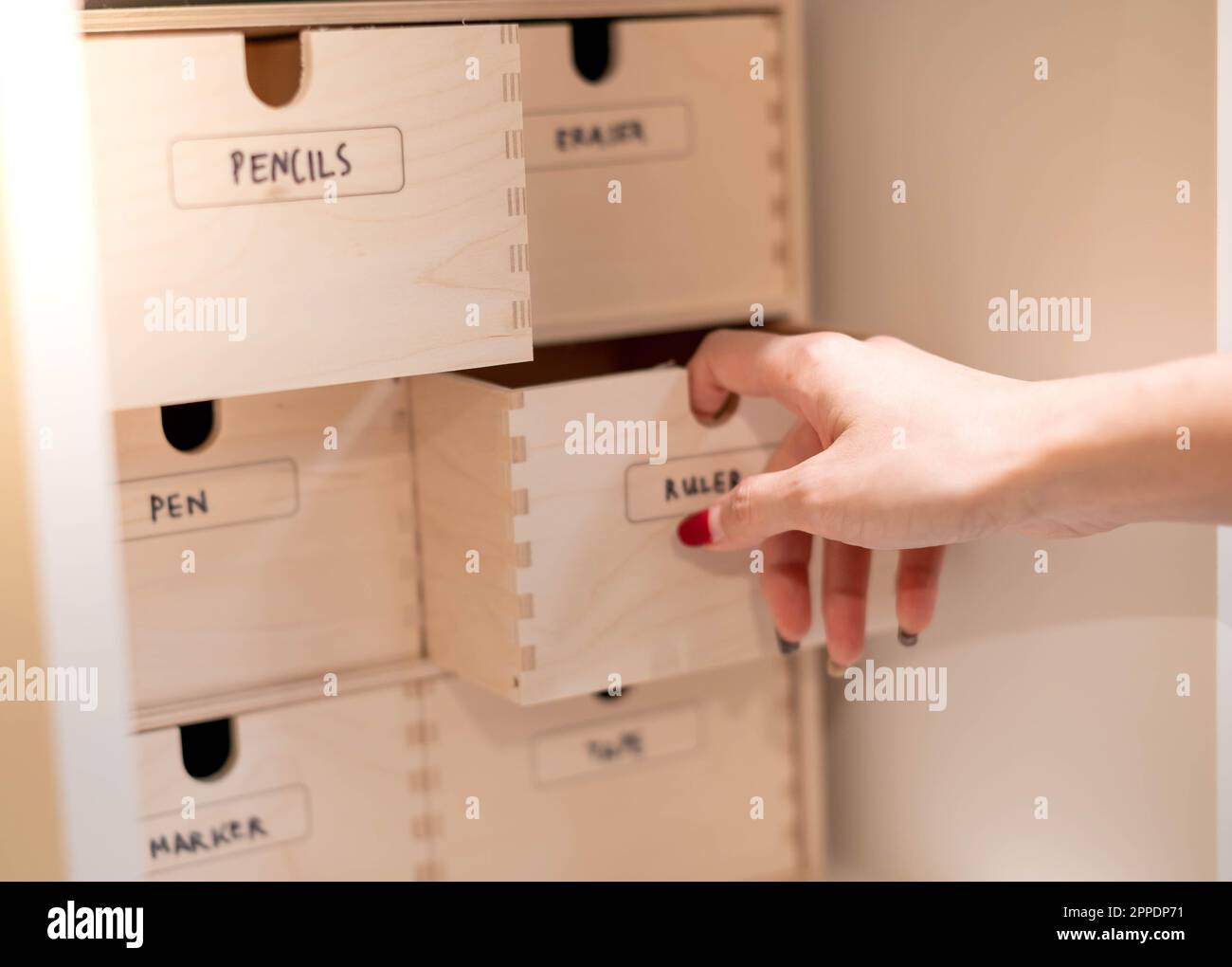 Female hand opening drawer with office tools that put on the wood shelf ...