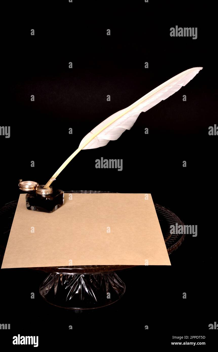 Quill parchment and ink well isolated over black Stock Photo - Alamy