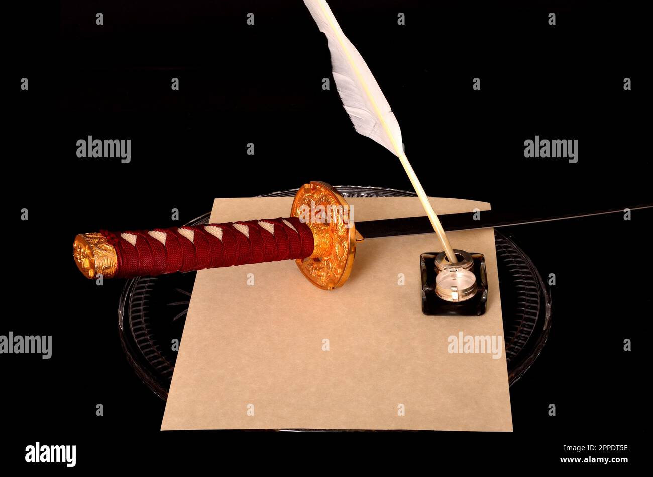 Quill parchment sword and ink well isolated over black Stock Photo - Alamy